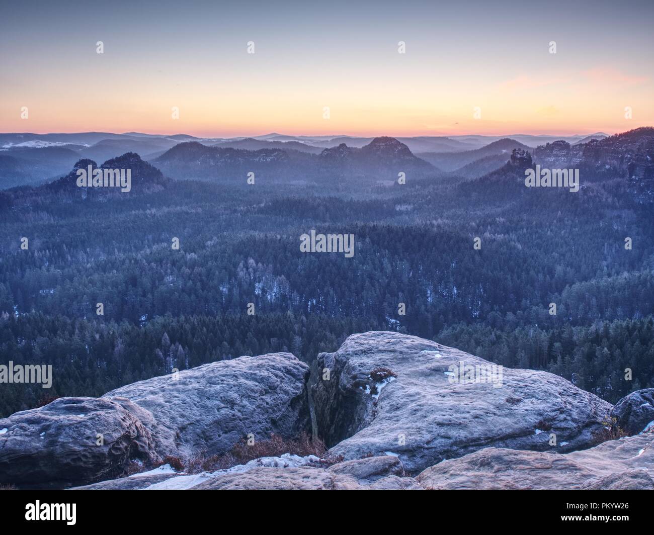 Exposed sandstone cliff above deep misty valley at beginning of hot ...