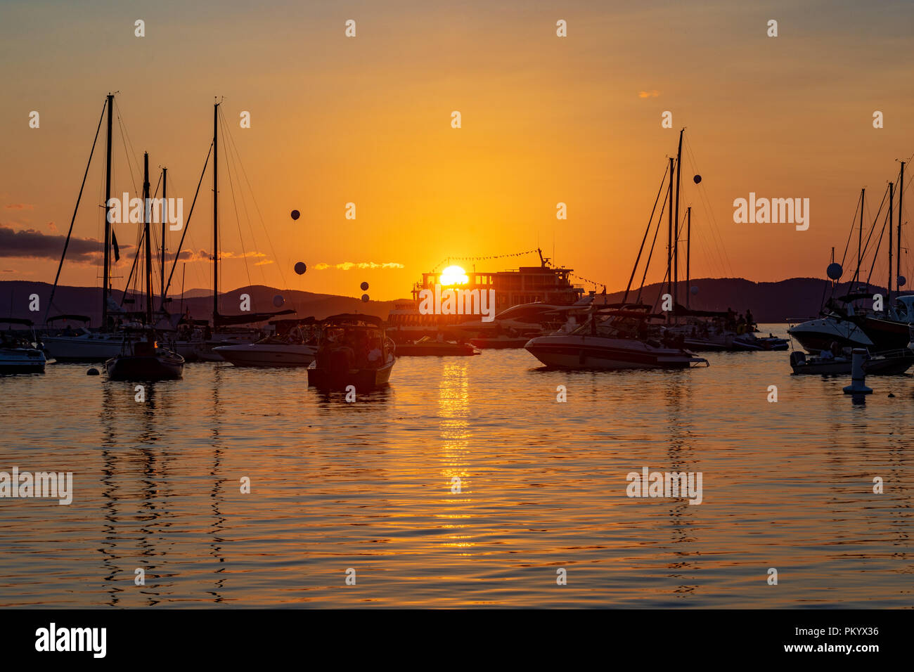Ferry Boat passing in front of setting sun on Lake Champlain Stock ...