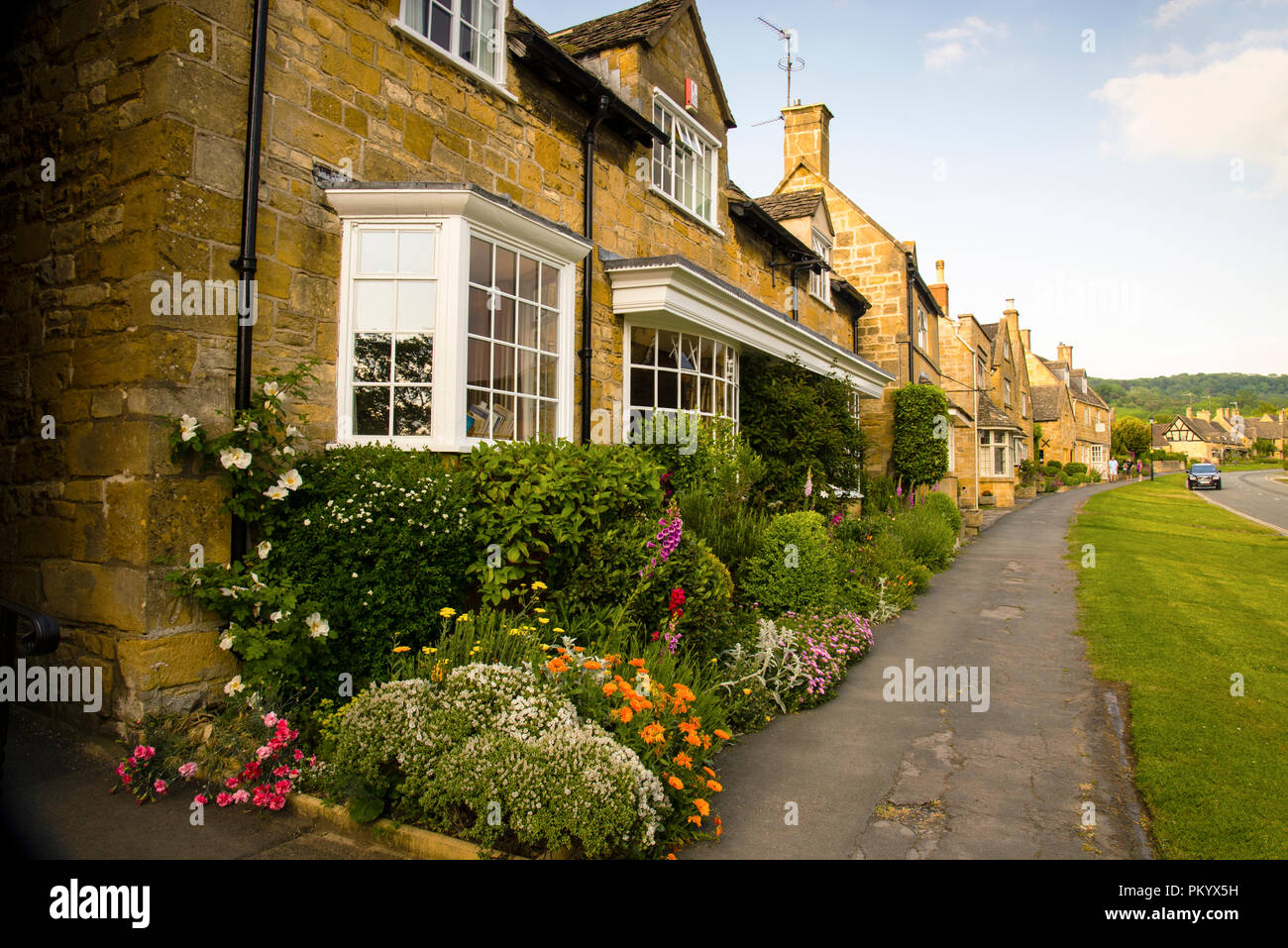 Broadway broad High Street lined with honey color Cotswold stone homes ...