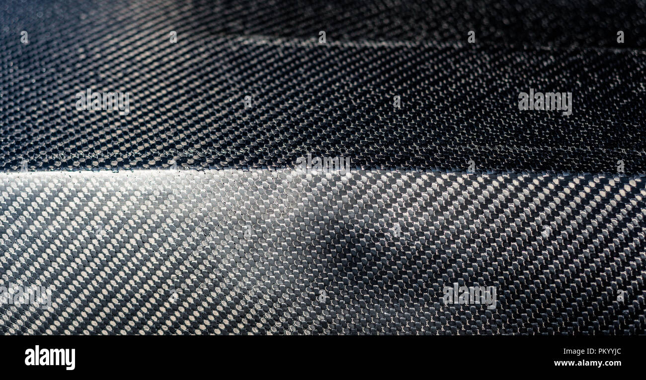 Background, carbon surface close up with the reflection of sunrays ...