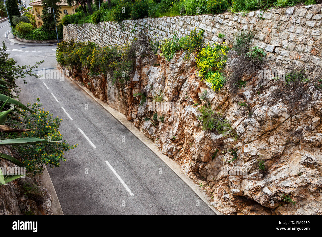 Asphalt road carved through rocks in Villefranche sur Mer, France Stock ...