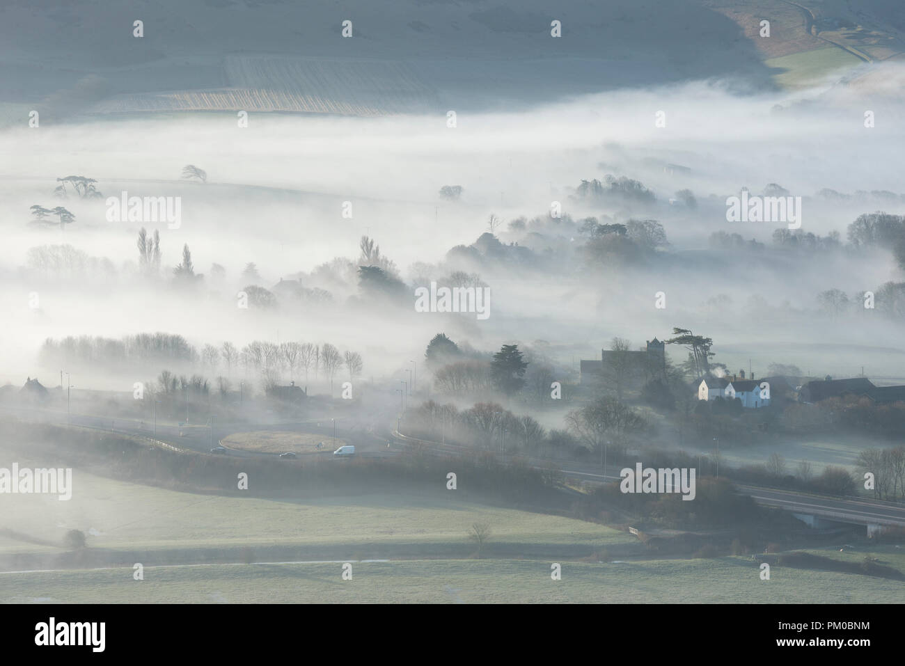 Beautiful foggy English countryside landscape at sunrise in Winter with ...
