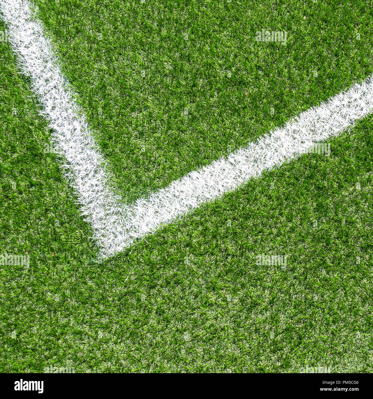 Green synthetic grass soccer sports field with white corner stripe line ...