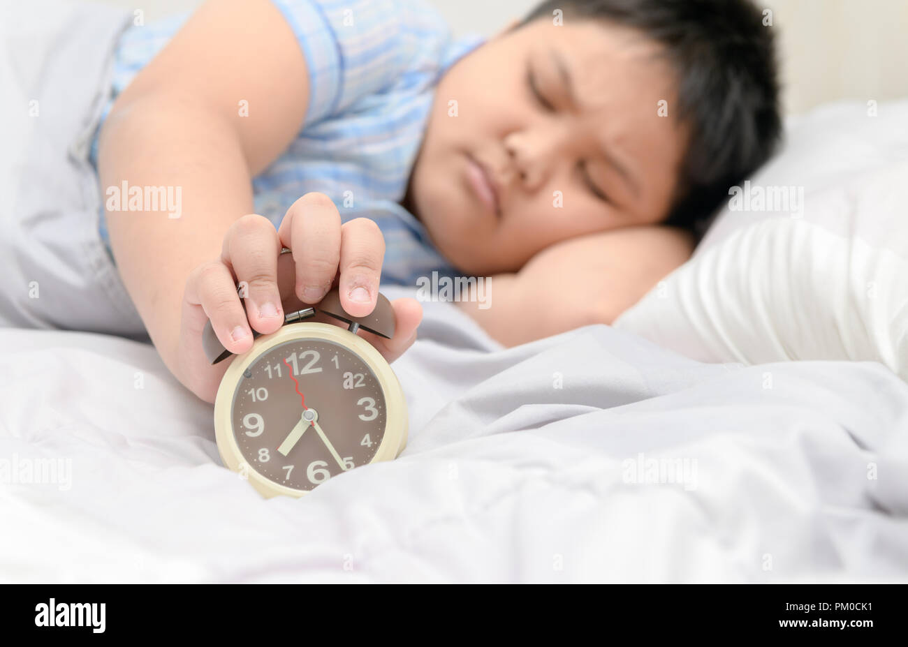Fat boy turns off the alarm clock waking up in the morning Stock Photo ...
