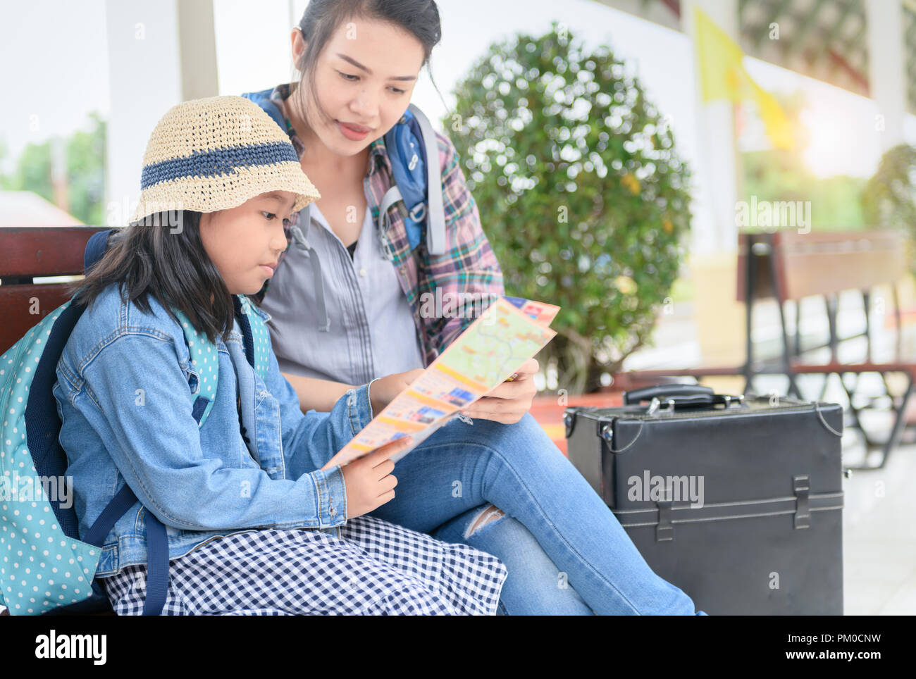 kid read map with mother at the train station. Travel and vacation ...