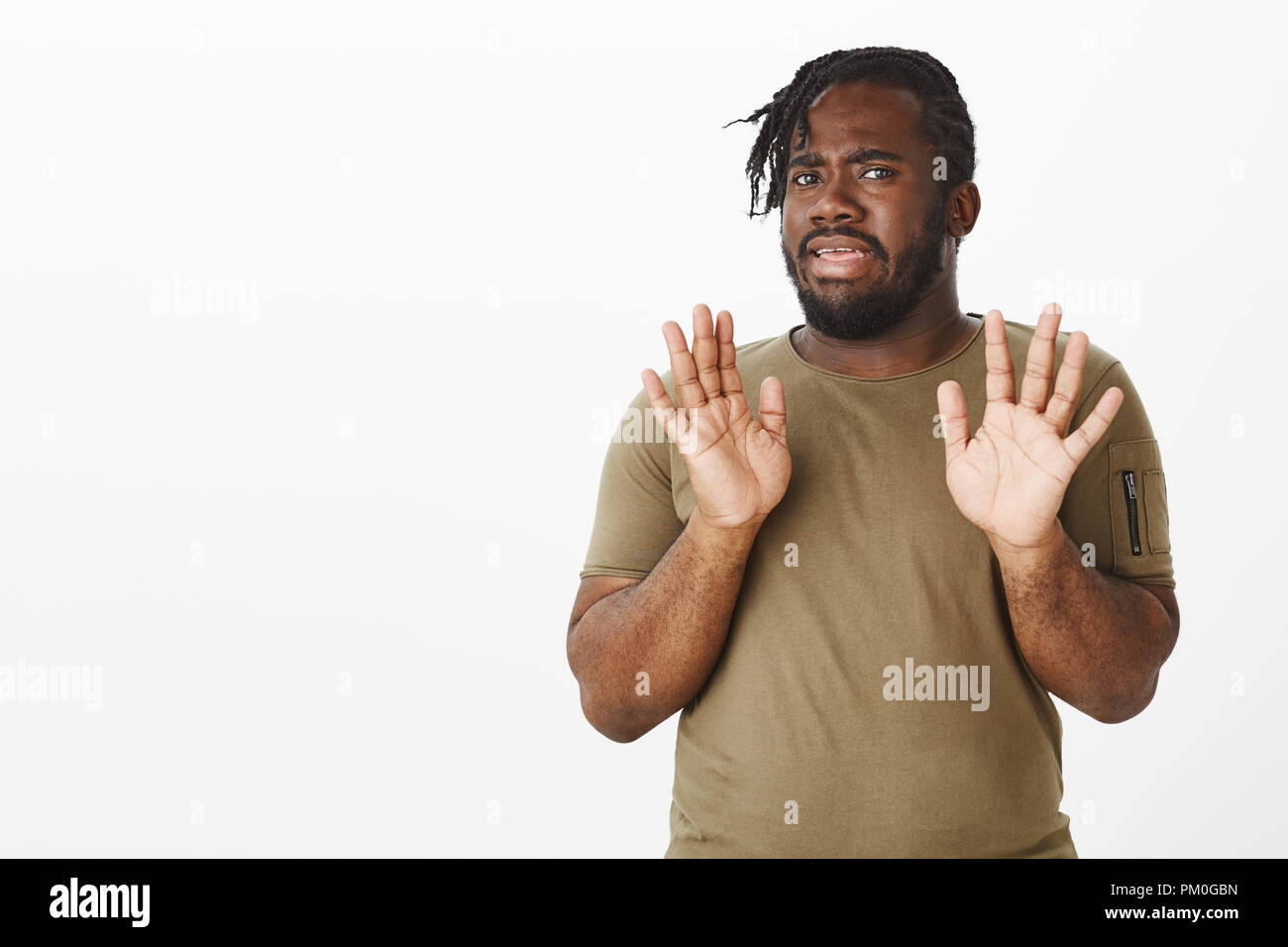 Intense displeased attractive plump guy with dark skin, raising palms ...