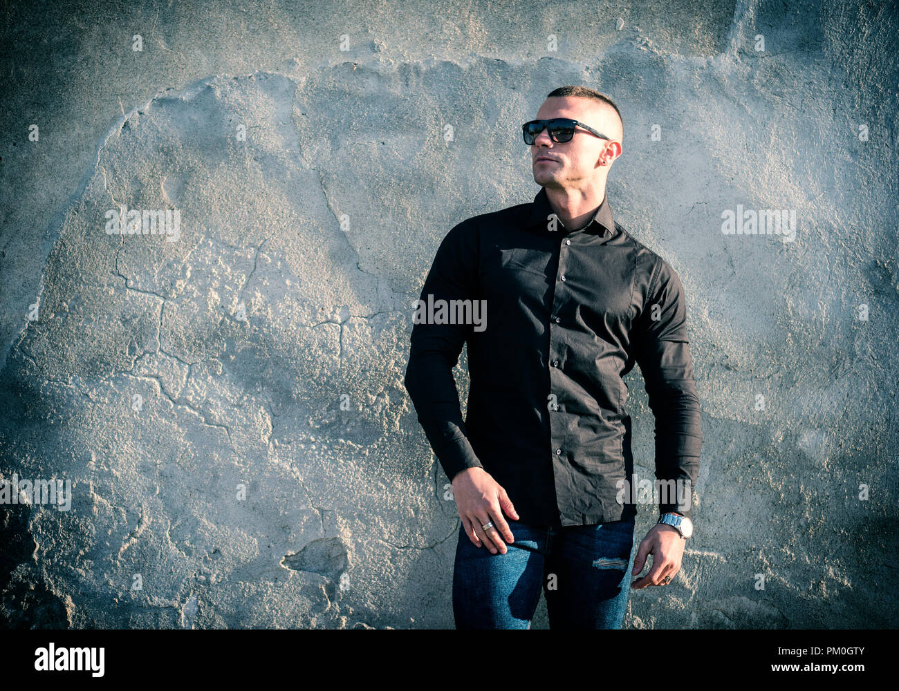 One handsome young man in urban setting in European city, standing ...