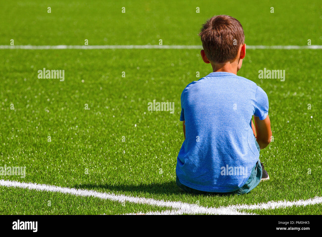 Sad alone boy sitting in soccer field stadium outdoors Stock Photo - Alamy