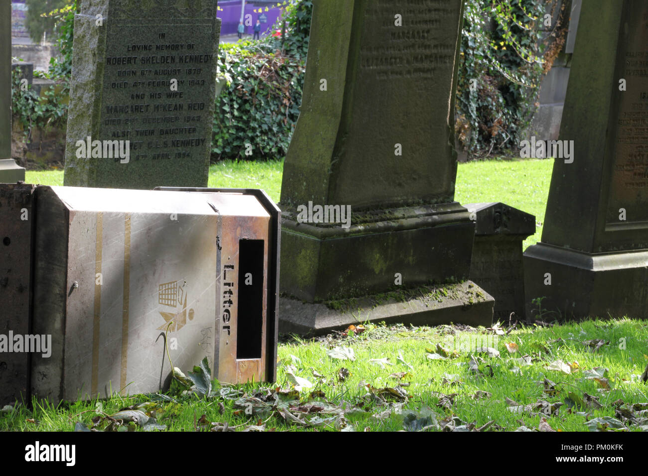 A knocked over litter bin sitting amongst the gravestones in the ...