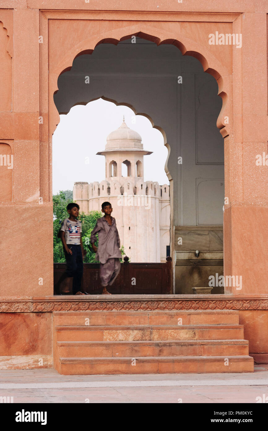 Lahore, Punjab, Pakistan, South Asia : Two chidren walk through an arch ...