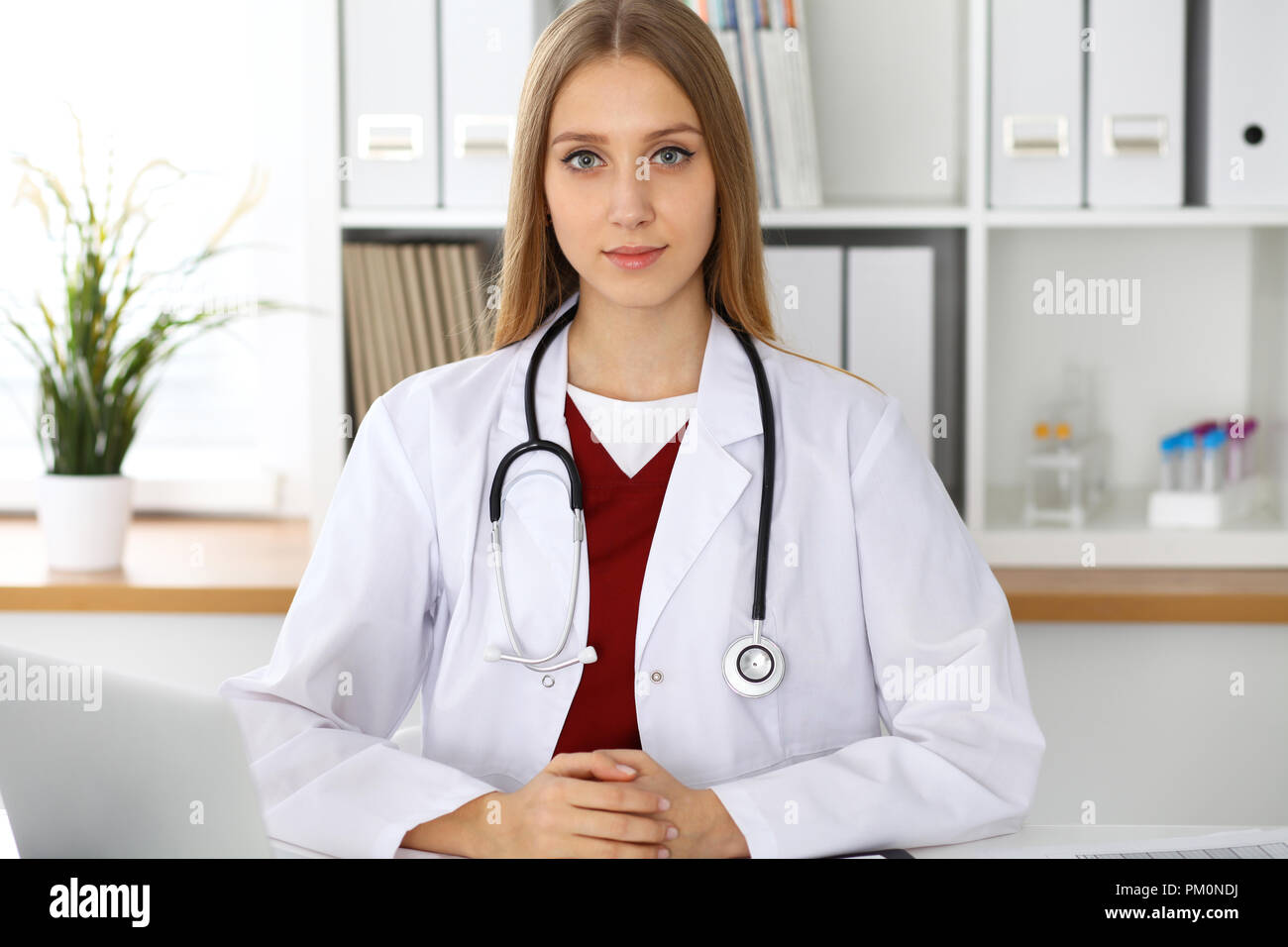 Brunette female doctor using laptop computer in hospital. Healthcare ...
