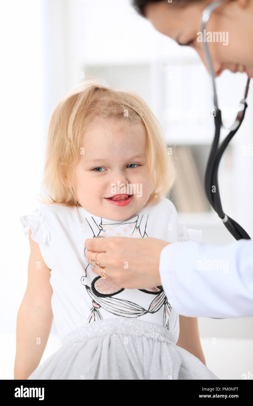 Doctor and patient baby in hospital. Little girl is being examined by ...