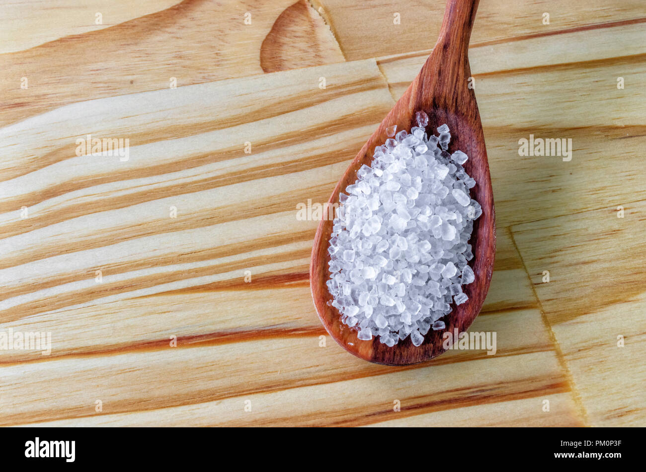 white granulated salt on wooden background Stock Photo - Alamy