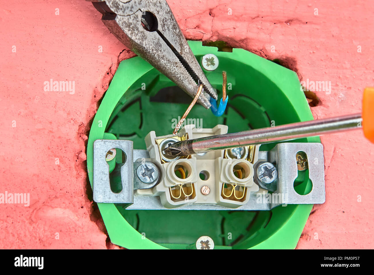 The electrician uses pliers and a screwdriver when installing an ...