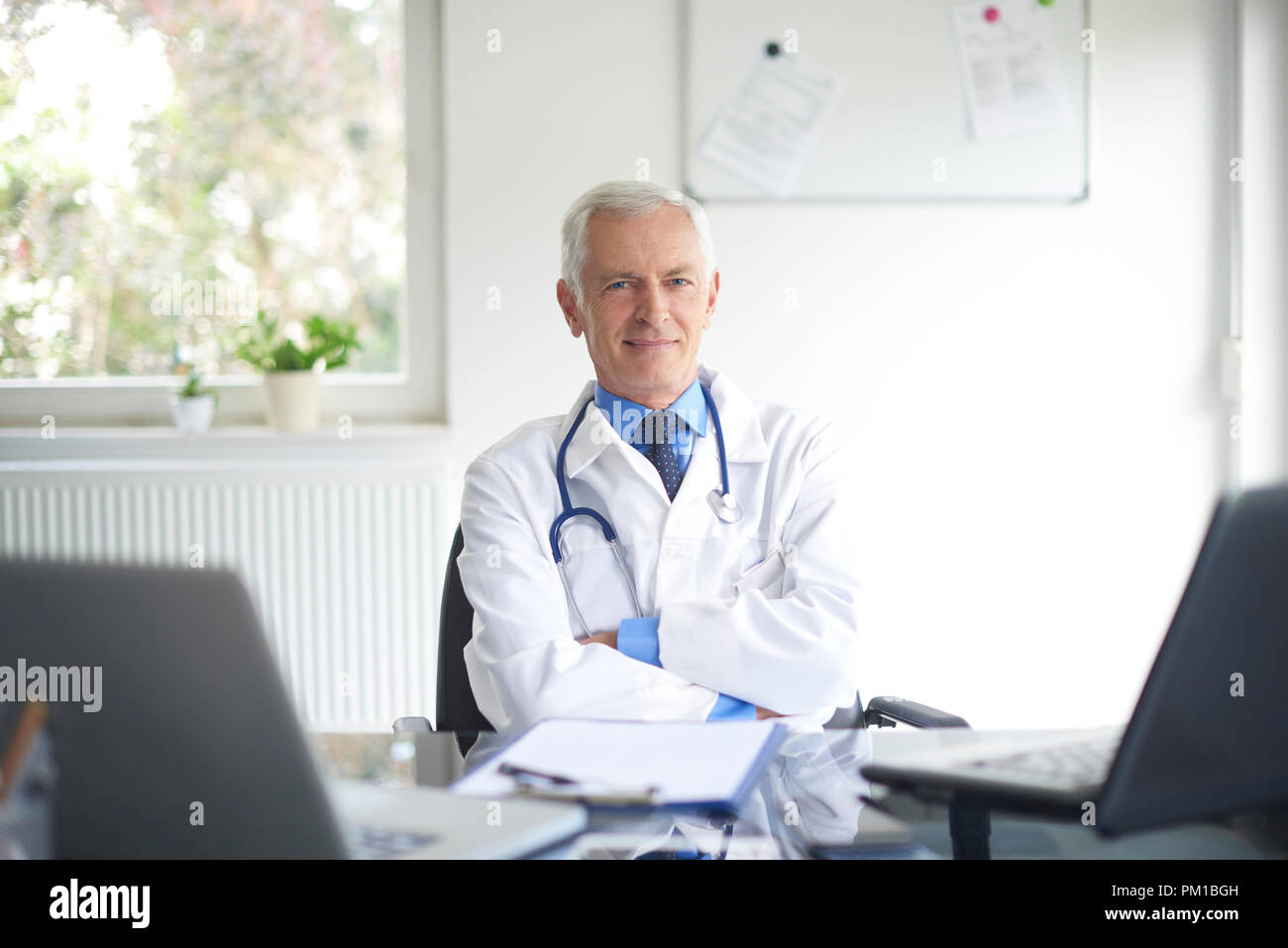 Male doctor smiling camera sitting hi-res stock photography and images ...
