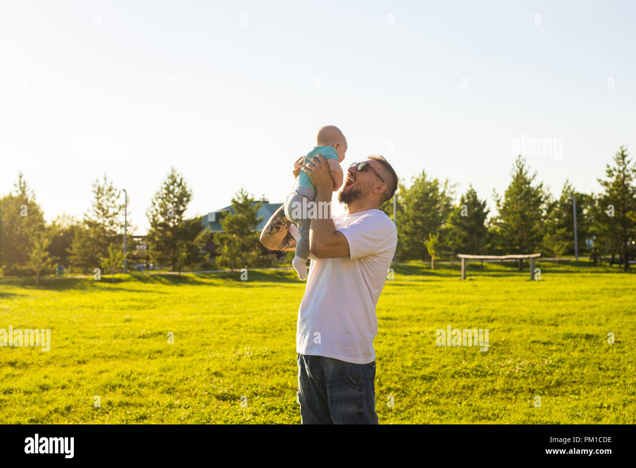 Happy father holding baby son, throwing baby in air. Concept of happy ...