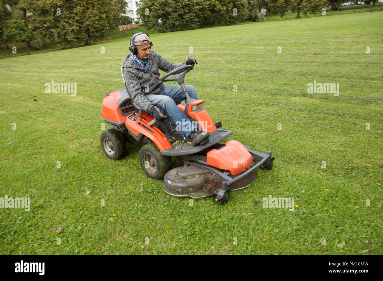 lawn mower tractor working in the town park Stock Photo - Alamy