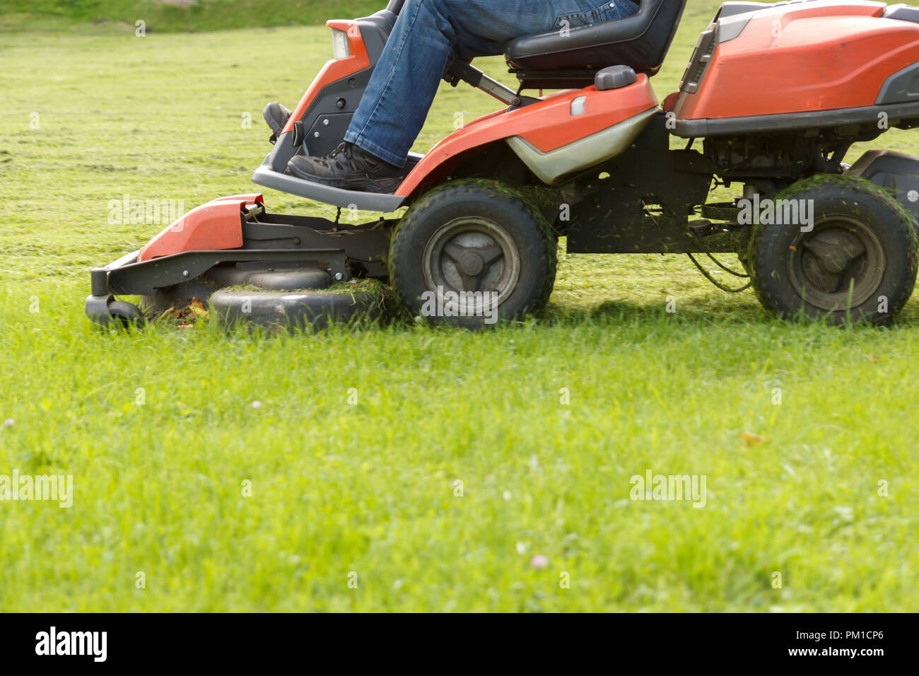 lawn mower tractor working in the town park Stock Photo - Alamy