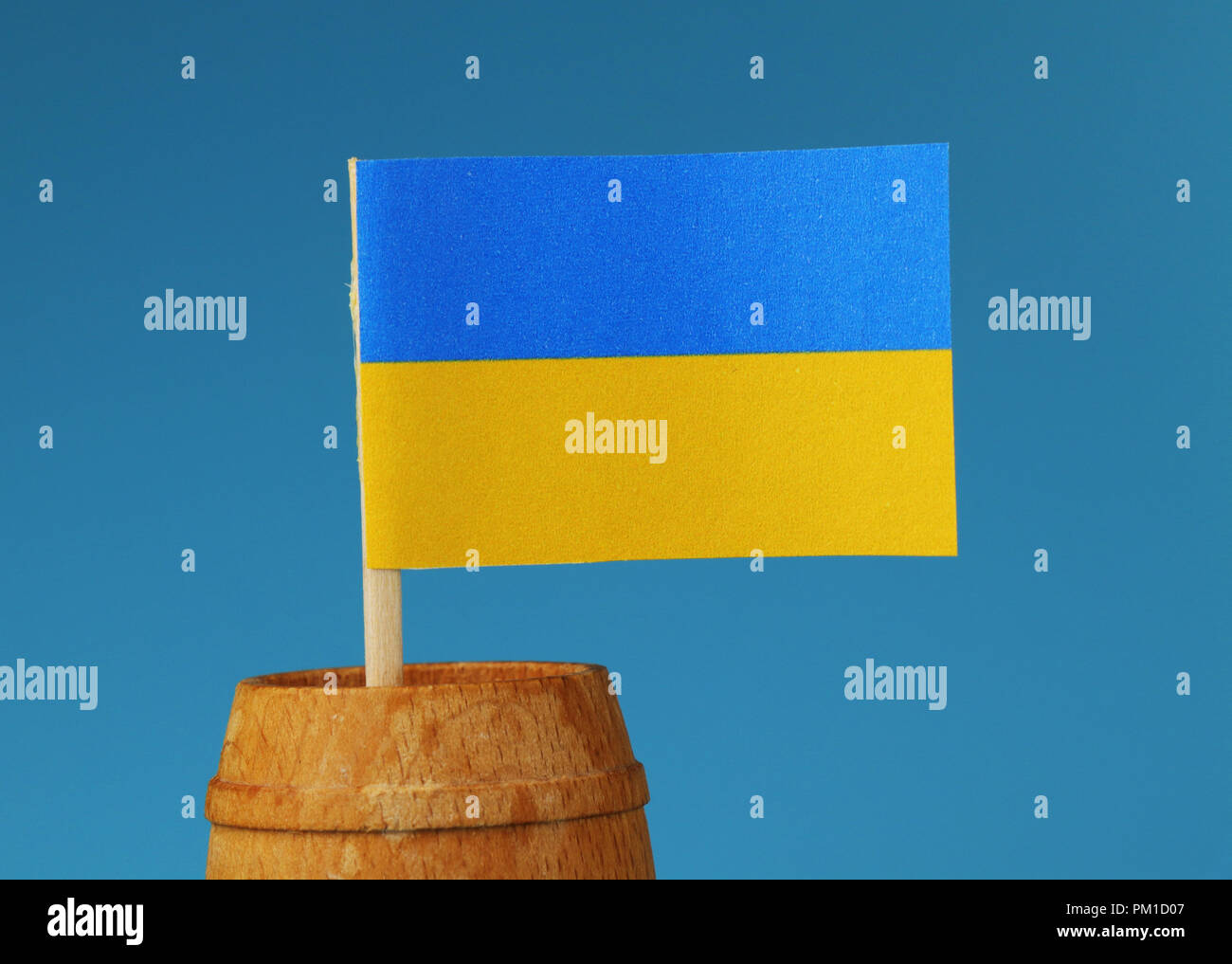 A detail on paper flag of Ukraine on wooden stick in wooden barrel ...