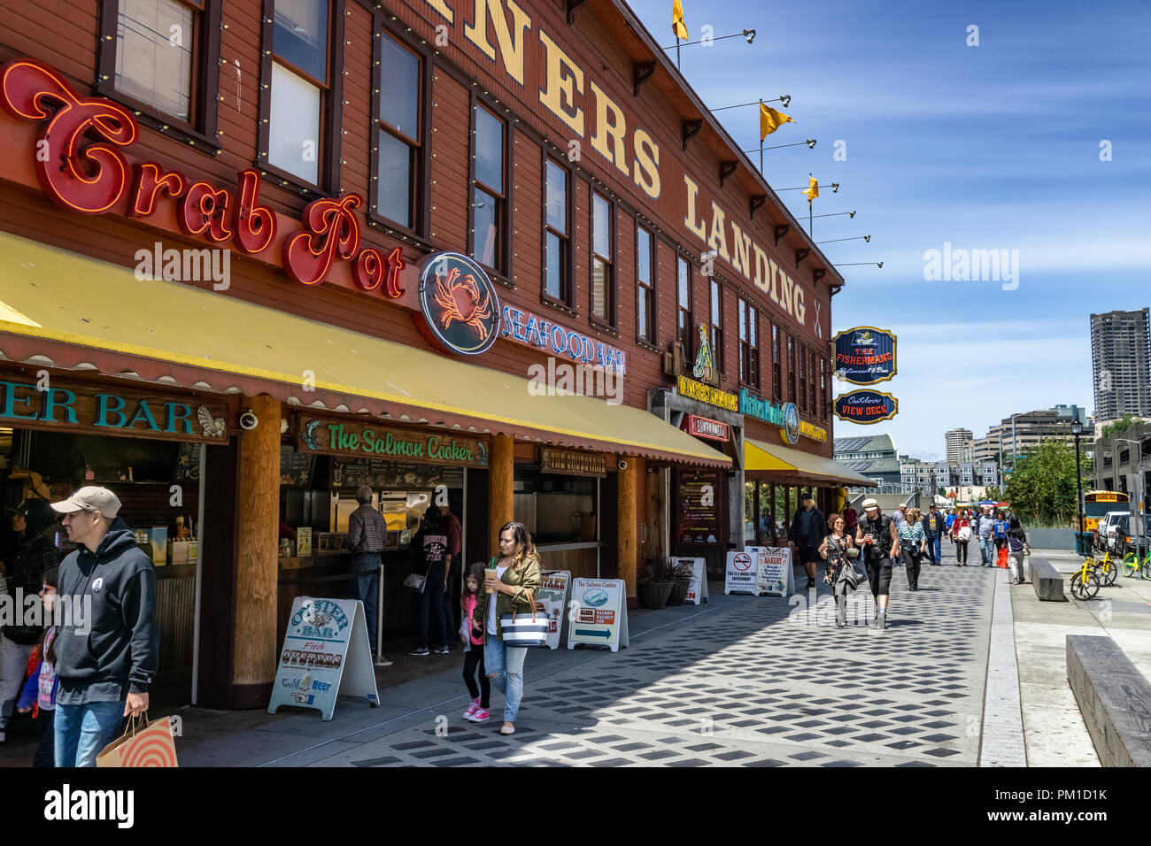 Miners Landing Pier 57 building with people walking along the Alaskan ...