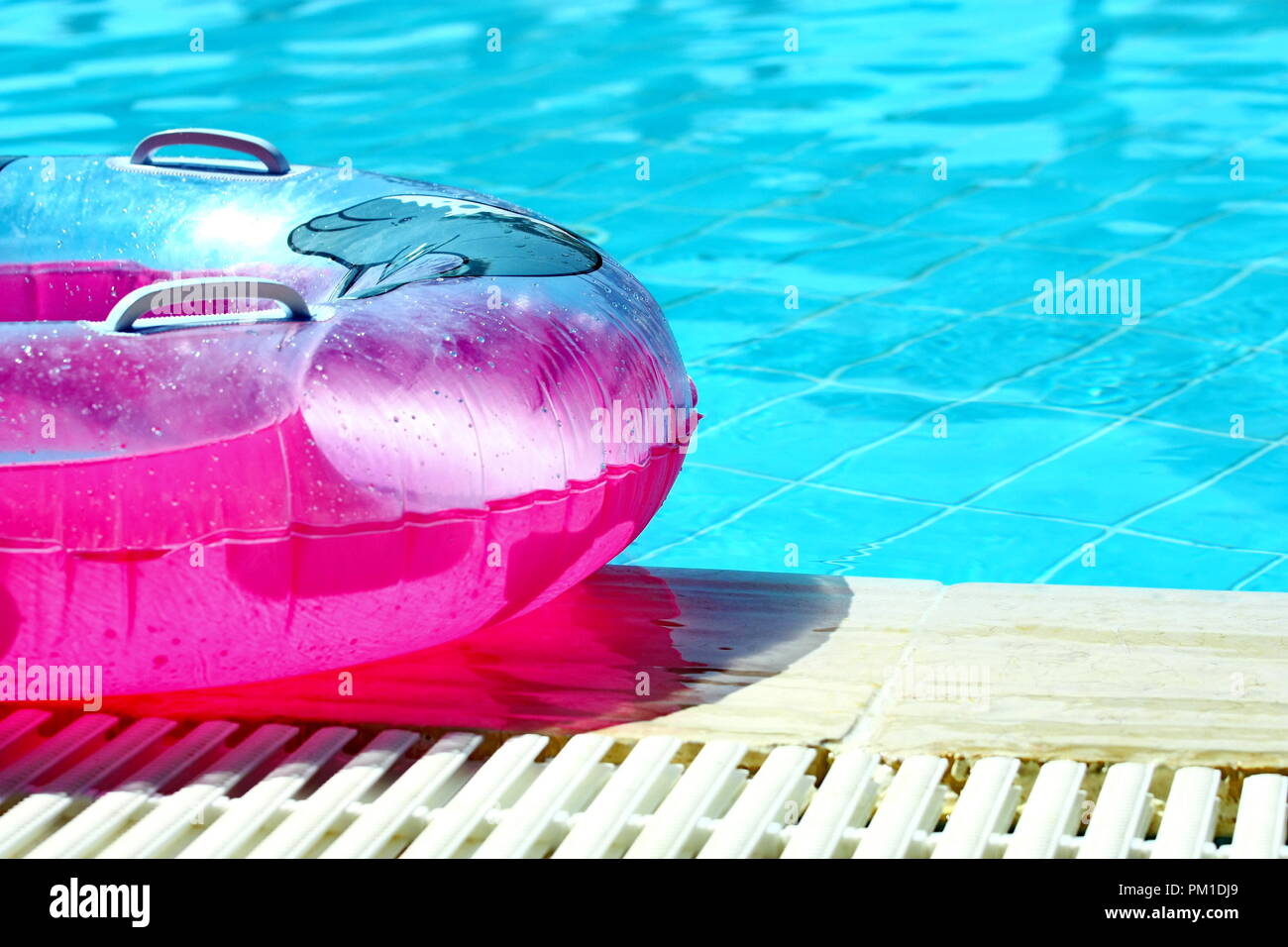 Pink inflatable round tube in swimming pool Stock Photo - Alamy