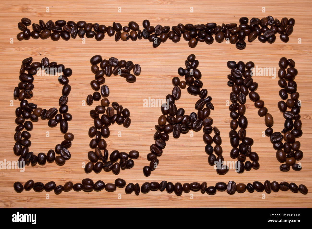The word "Bean" written out on a light wooden background formed from ...