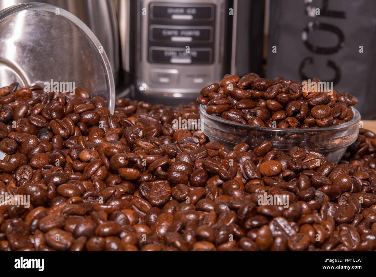 Roasted Coffee beans spilling out of two glass ramekins with a coffee ...