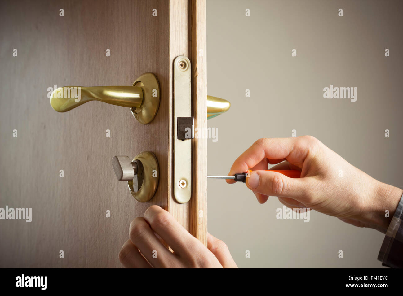 The carpenter repairs the door lock Stock Photo - Alamy