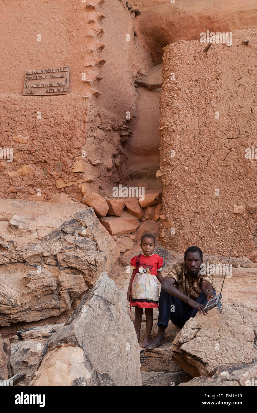 A man and a little girl in Youga Dogorou traditional Dogon village in ...