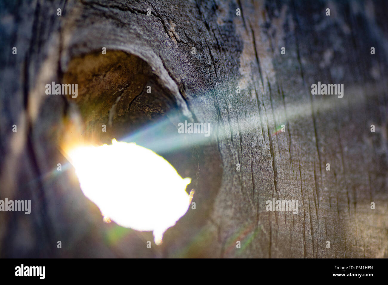 hole in fence sun shining in lens flare Stock Photo - Alamy