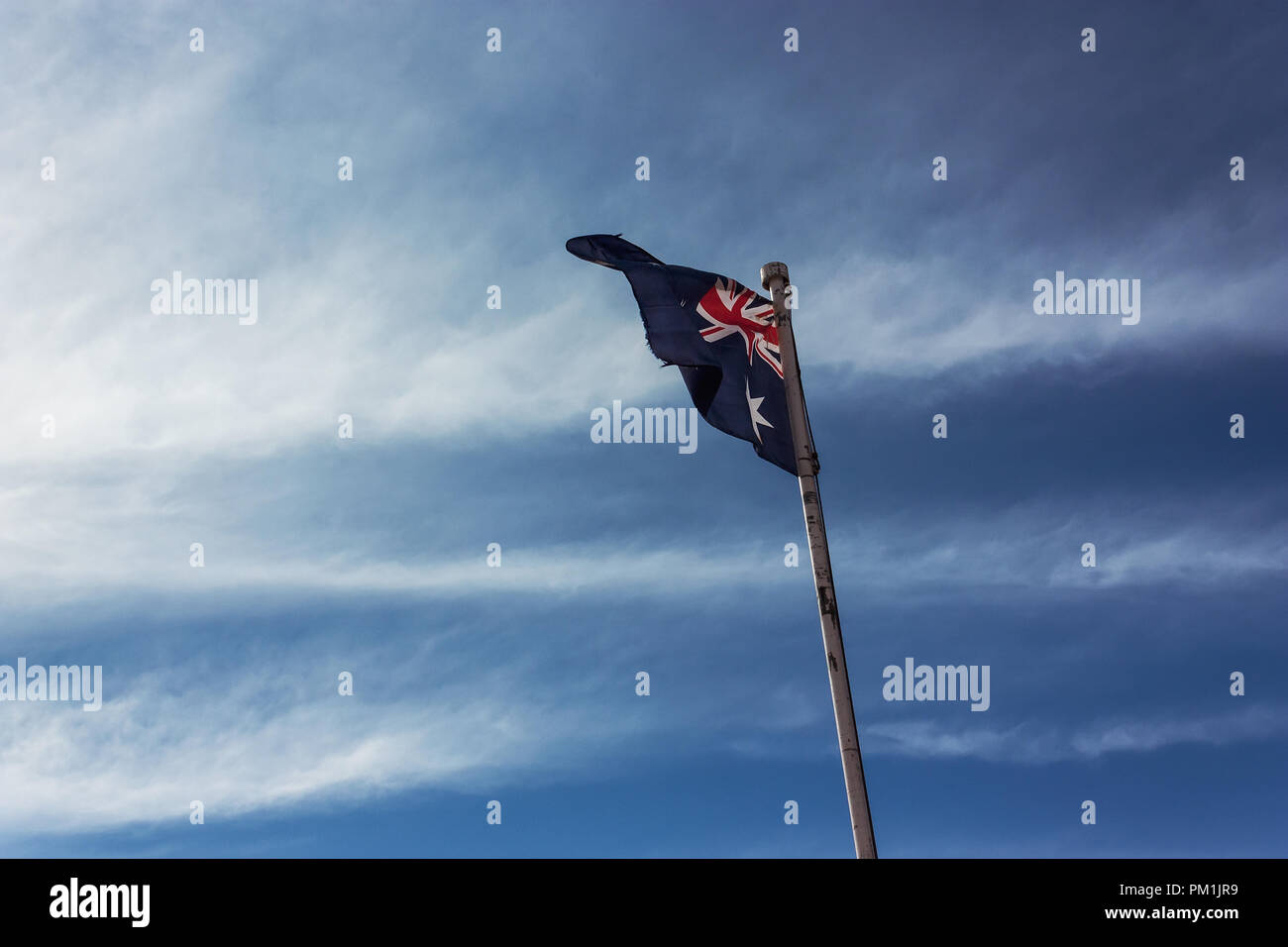 Australian flag waving in blue sky Stock Photo - Alamy
