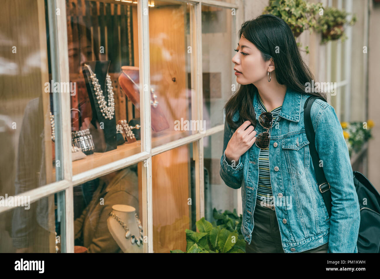 stylish female visitor doing a window shopping to beautiful and ...