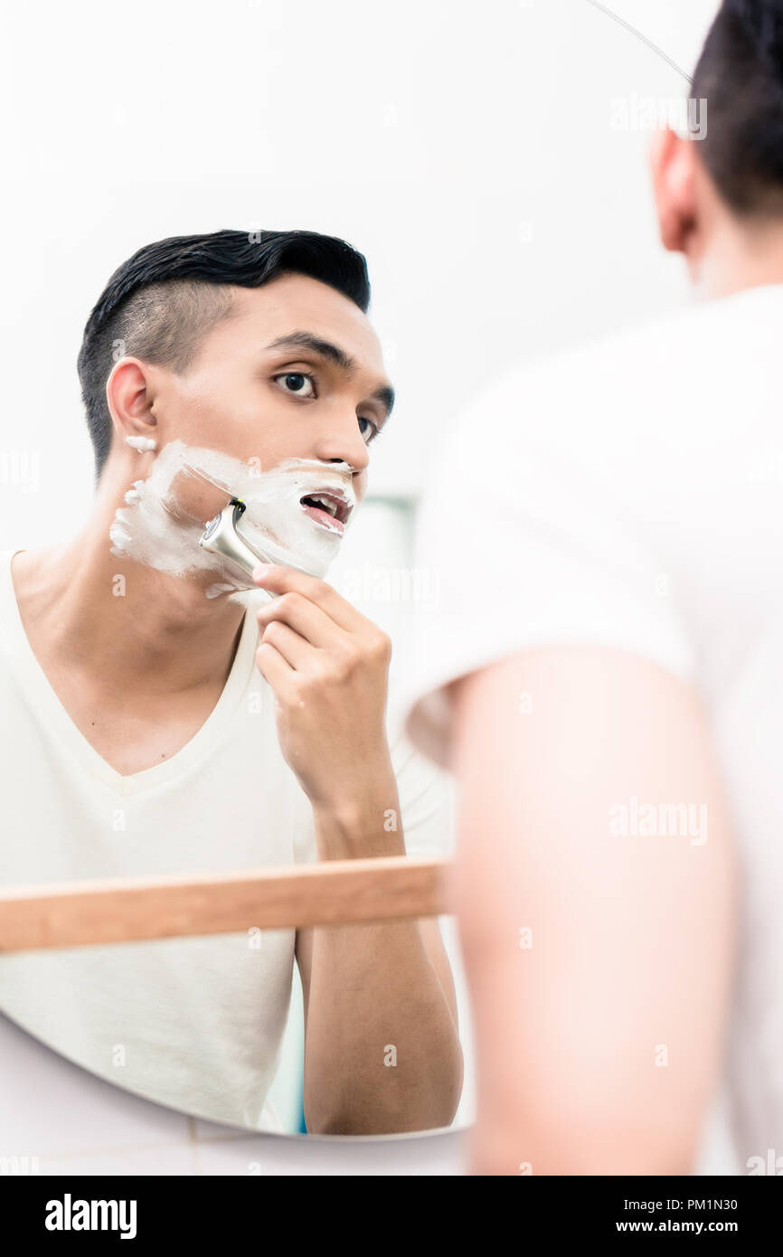 Man shaving in bathroom Stock Photo - Alamy