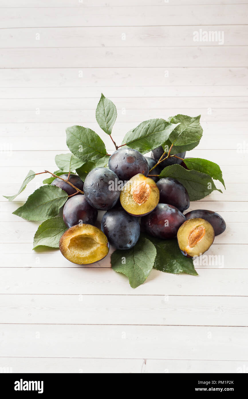 Fresh plum fruit with leaves on a light table Stock Photo - Alamy