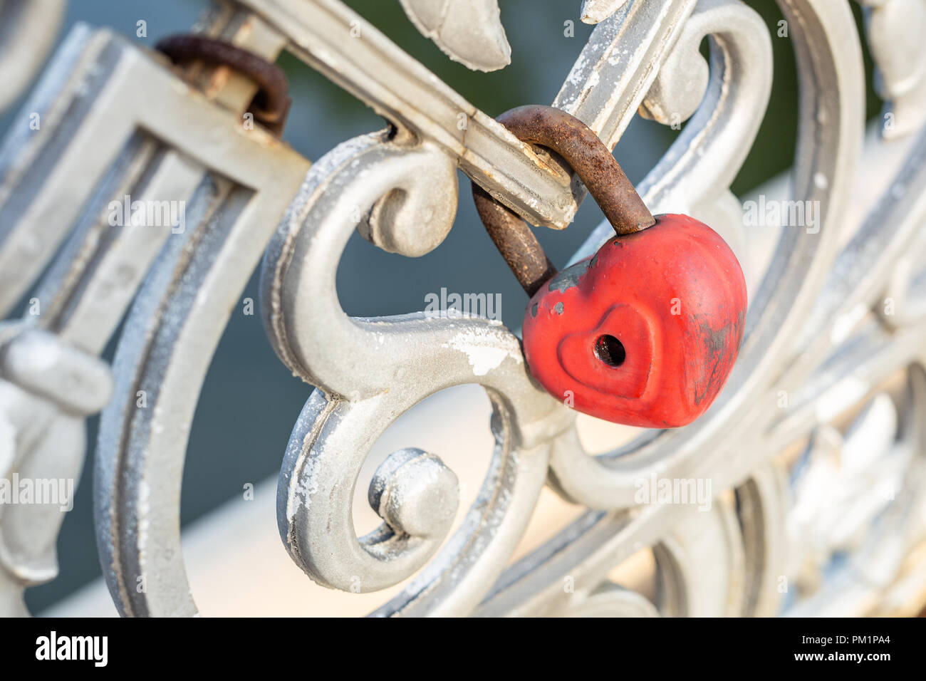 Red heart padlock locked on fence. Lock in shape of heart as symbol of ...