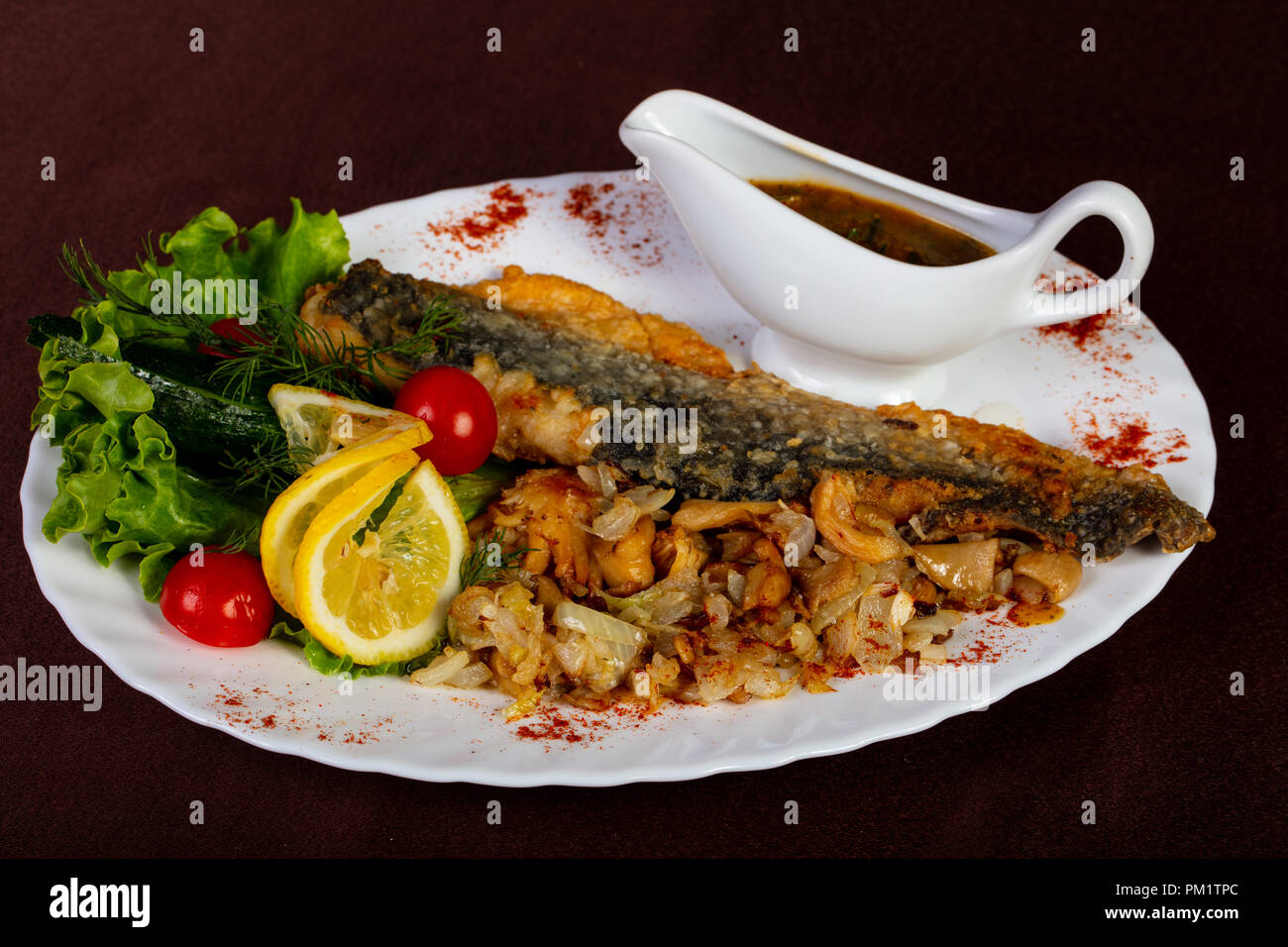 Roasted mullet fish with fried onion Stock Photo - Alamy
