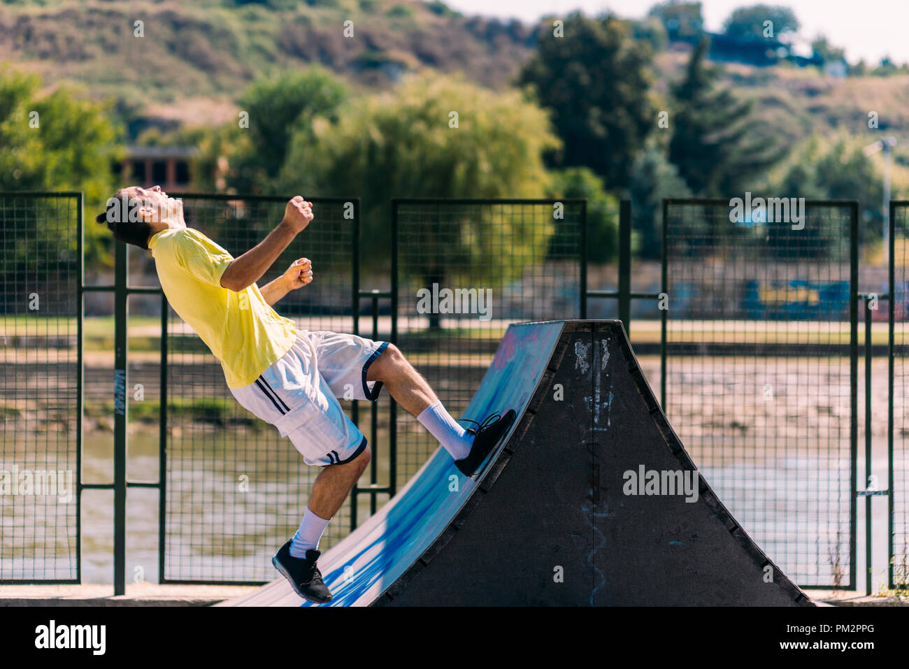 Athlete man exercising in skatepark while jumping over obstacles Stock ...