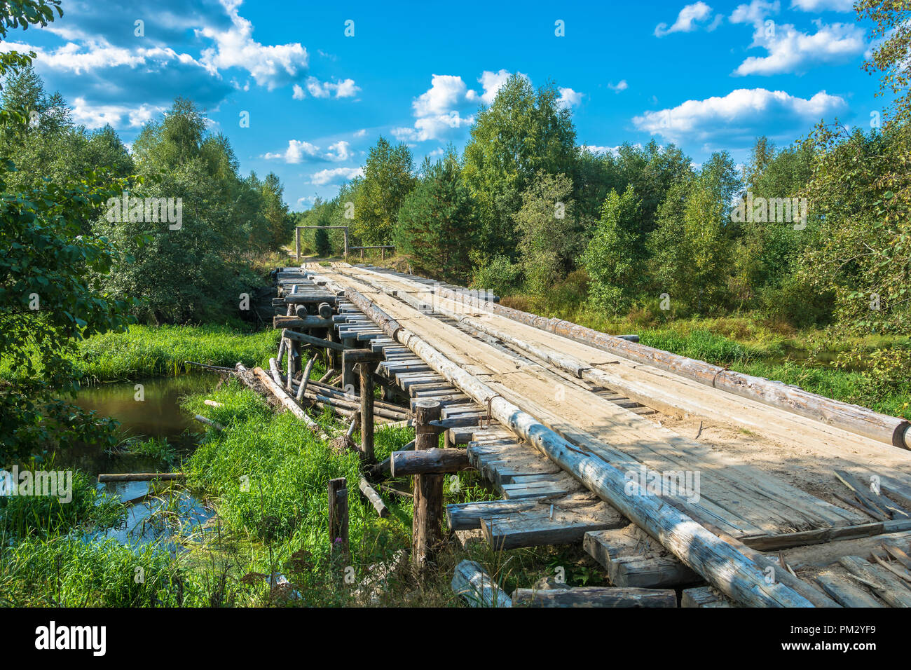 A wooden bridge across a small river in a summer sunny day Stock Photo ...