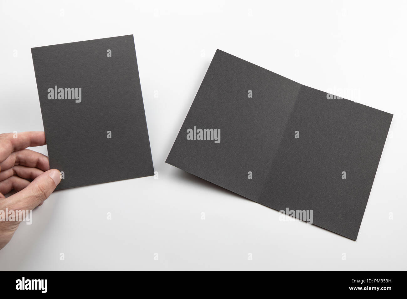 Mens hands holding empty black booklet on white background. View from ...