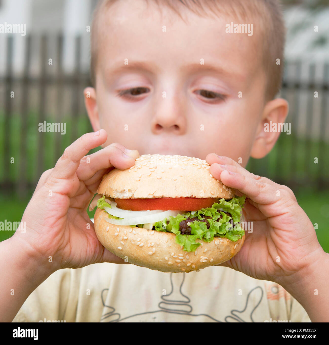 boy eats hamburger. A close up Stock Photo - Alamy