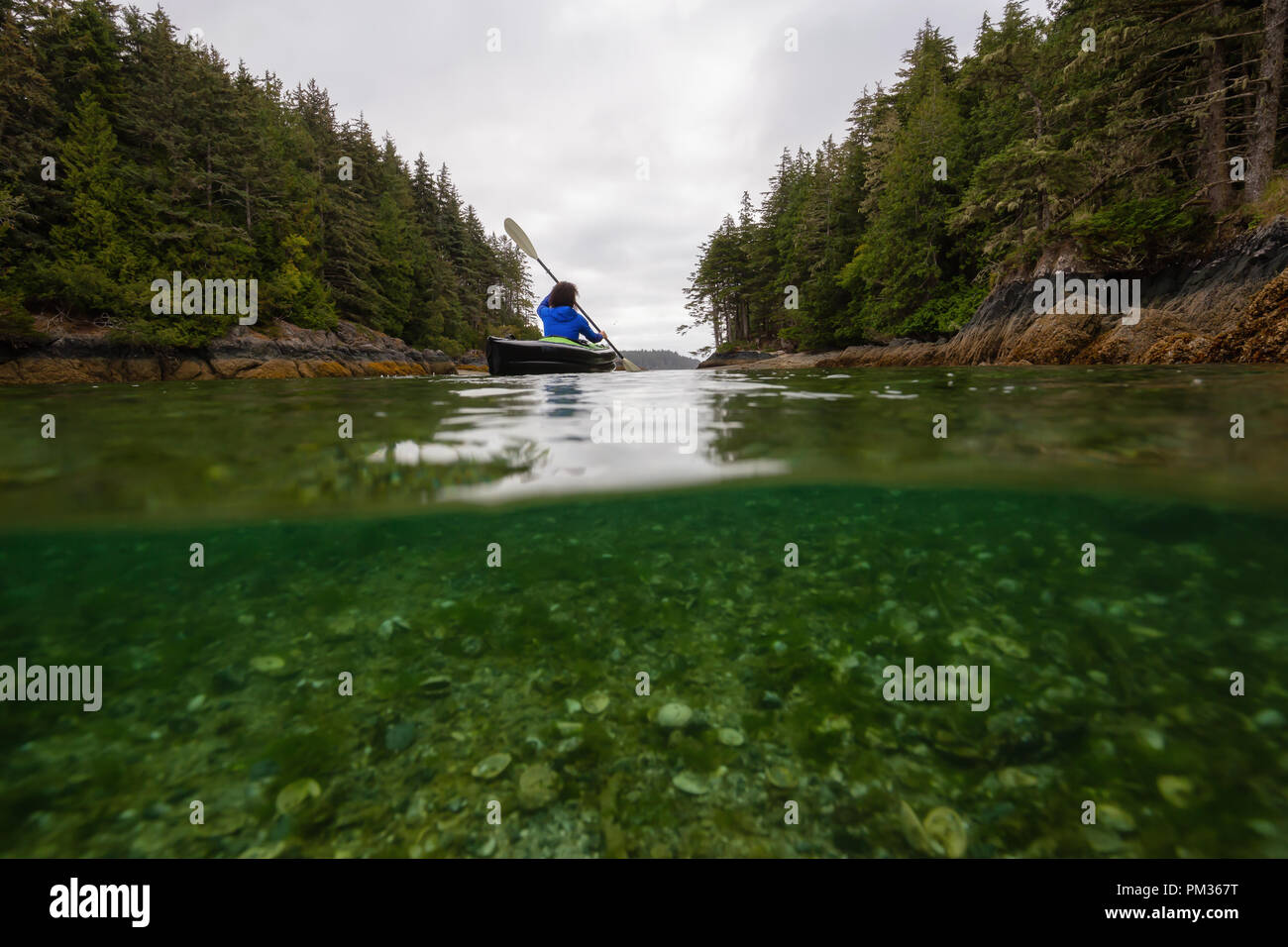 Over and Under picture of anAdventurous woman kayaking in the Pacific ...