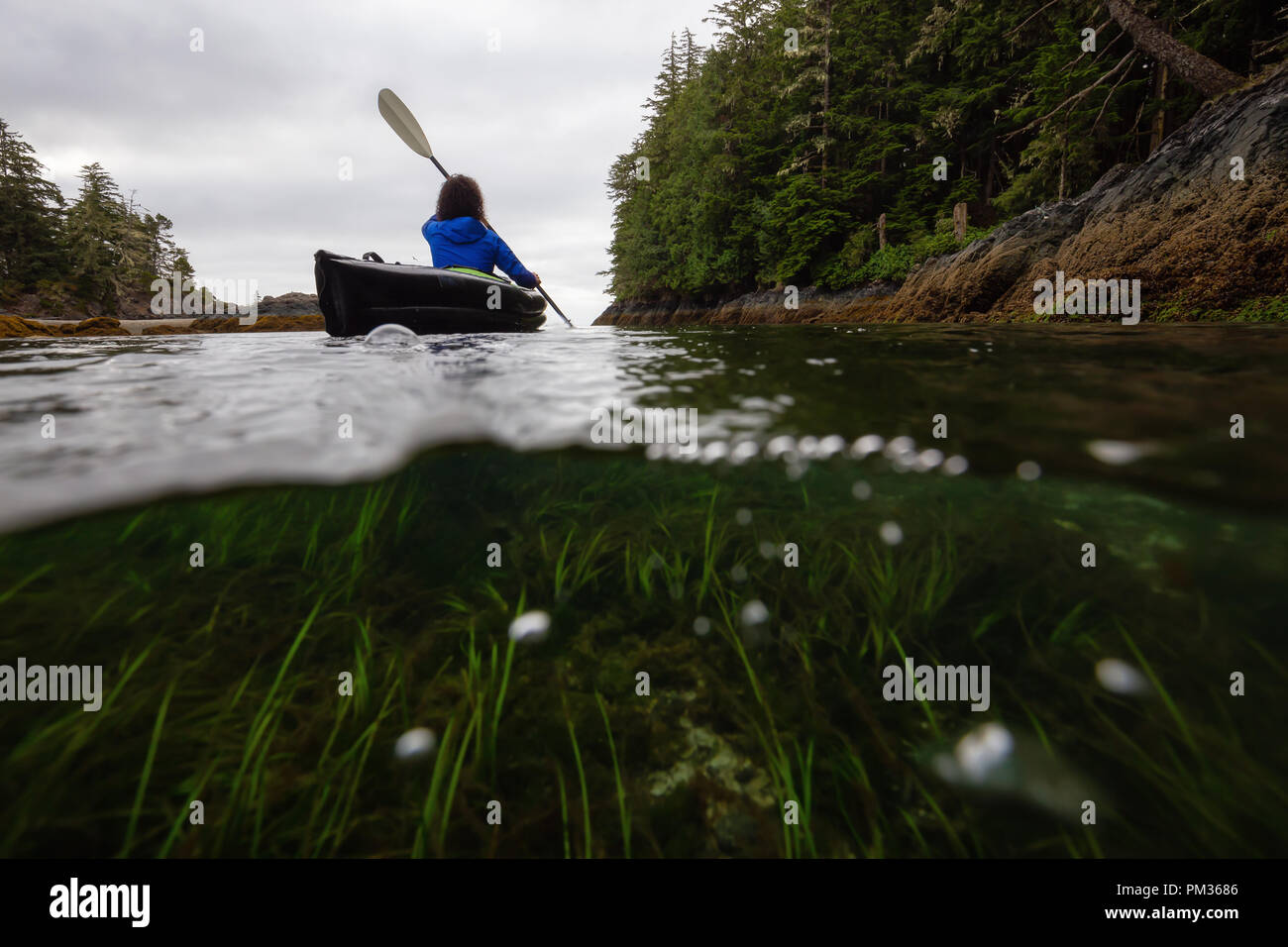Over and Under picture of anAdventurous woman kayaking in the Pacific ...