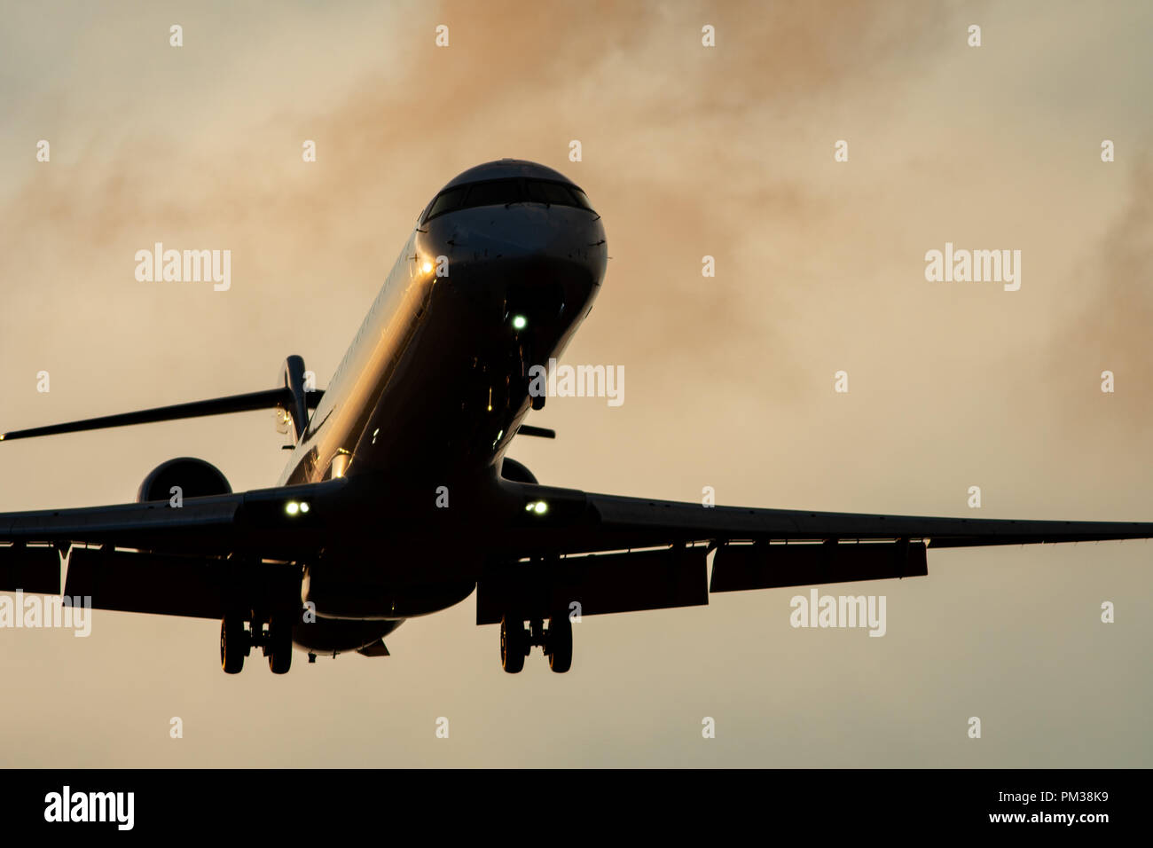 High contrast of jet plane with landing gear down, bottom view Stock ...