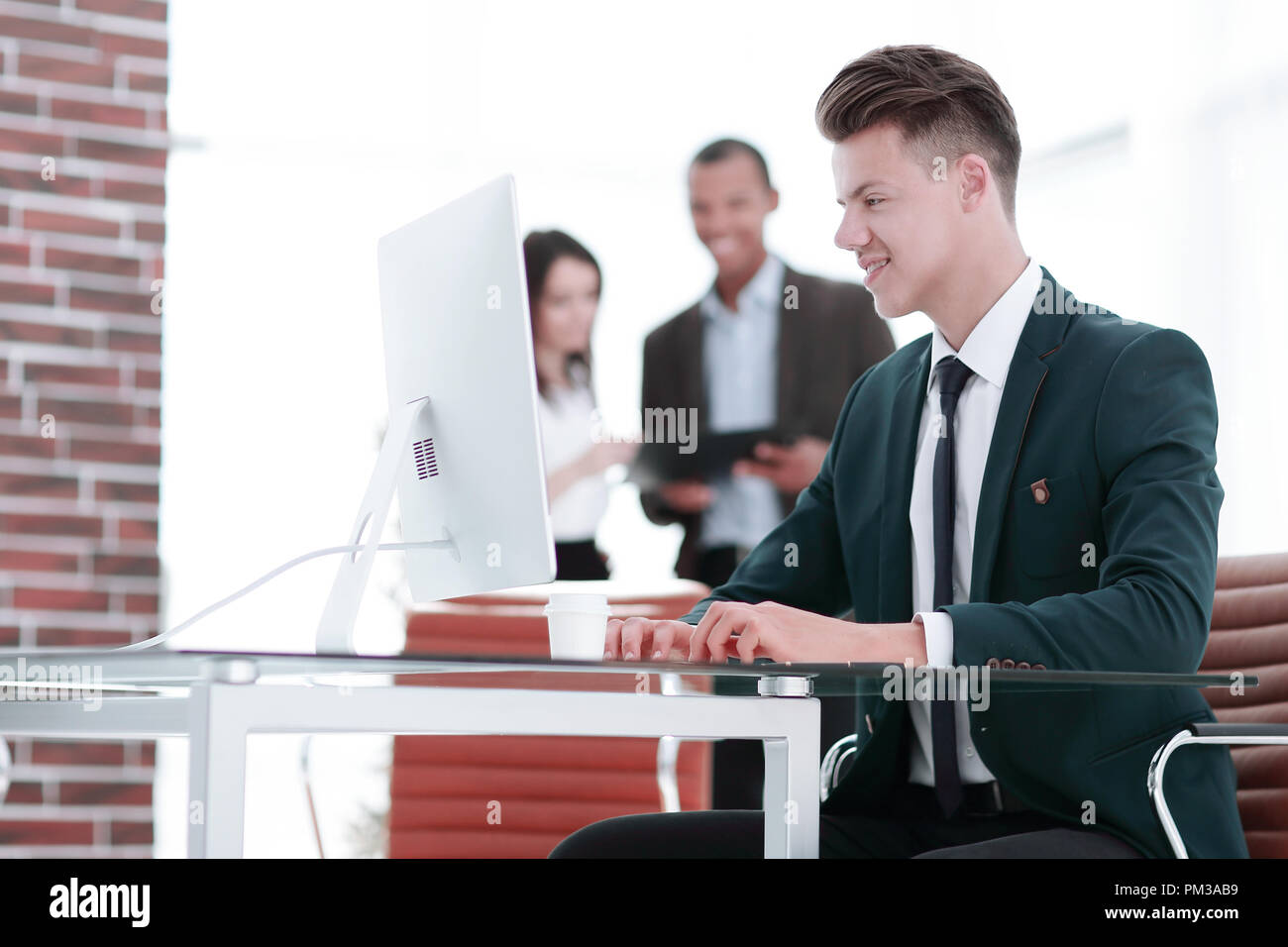 employee sitting behind a Desk in the office Stock Photo - Alamy