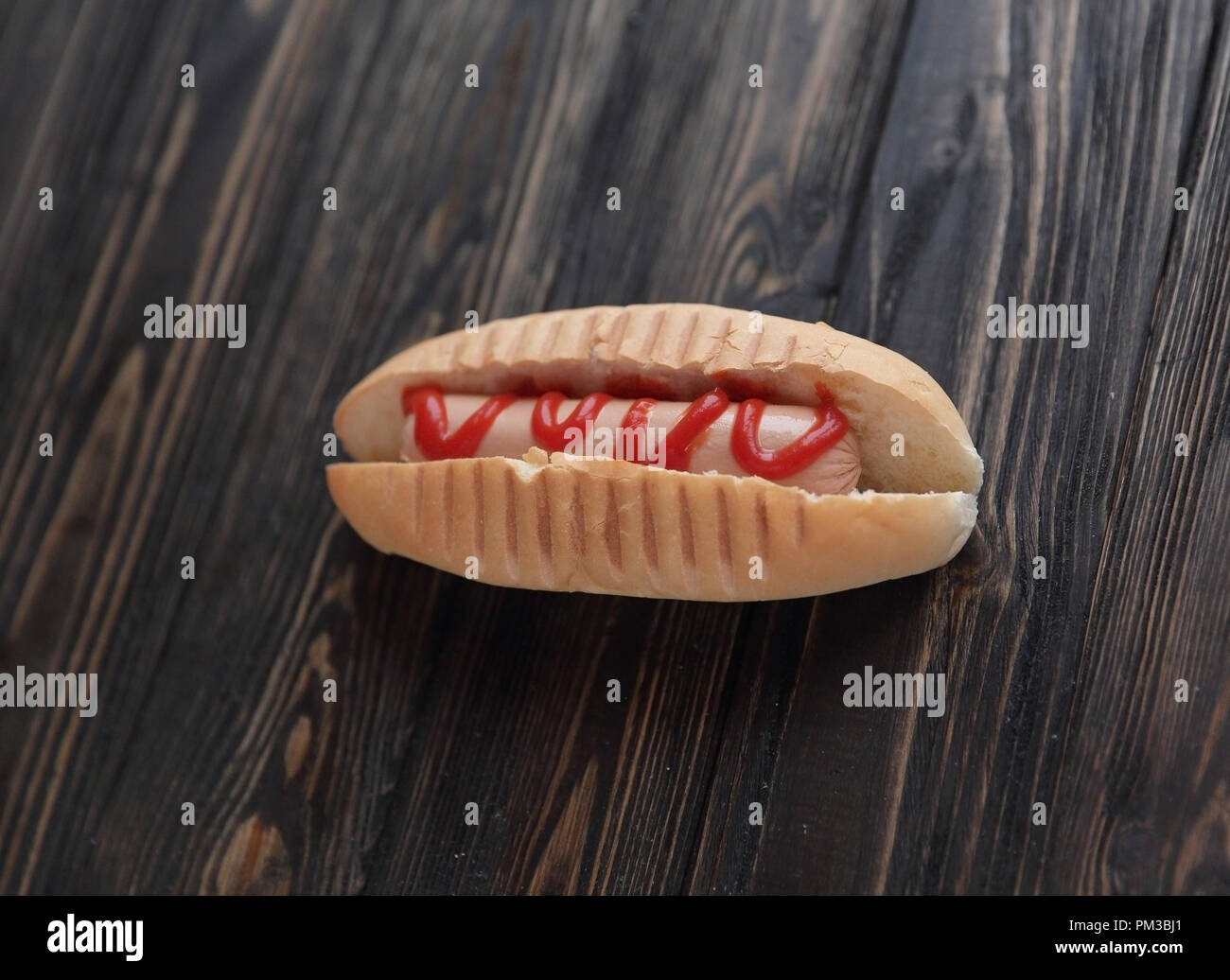 hotdog with tomato sauce on dark wooden background.photo with co Stock ...