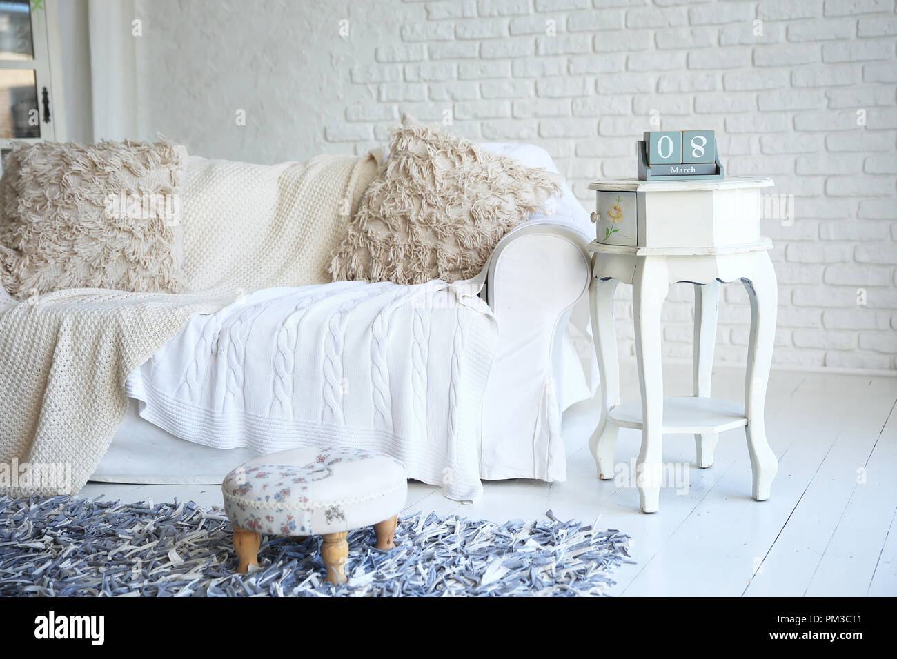 white sofa and nightstand with changeover calendar in a stylish living ...