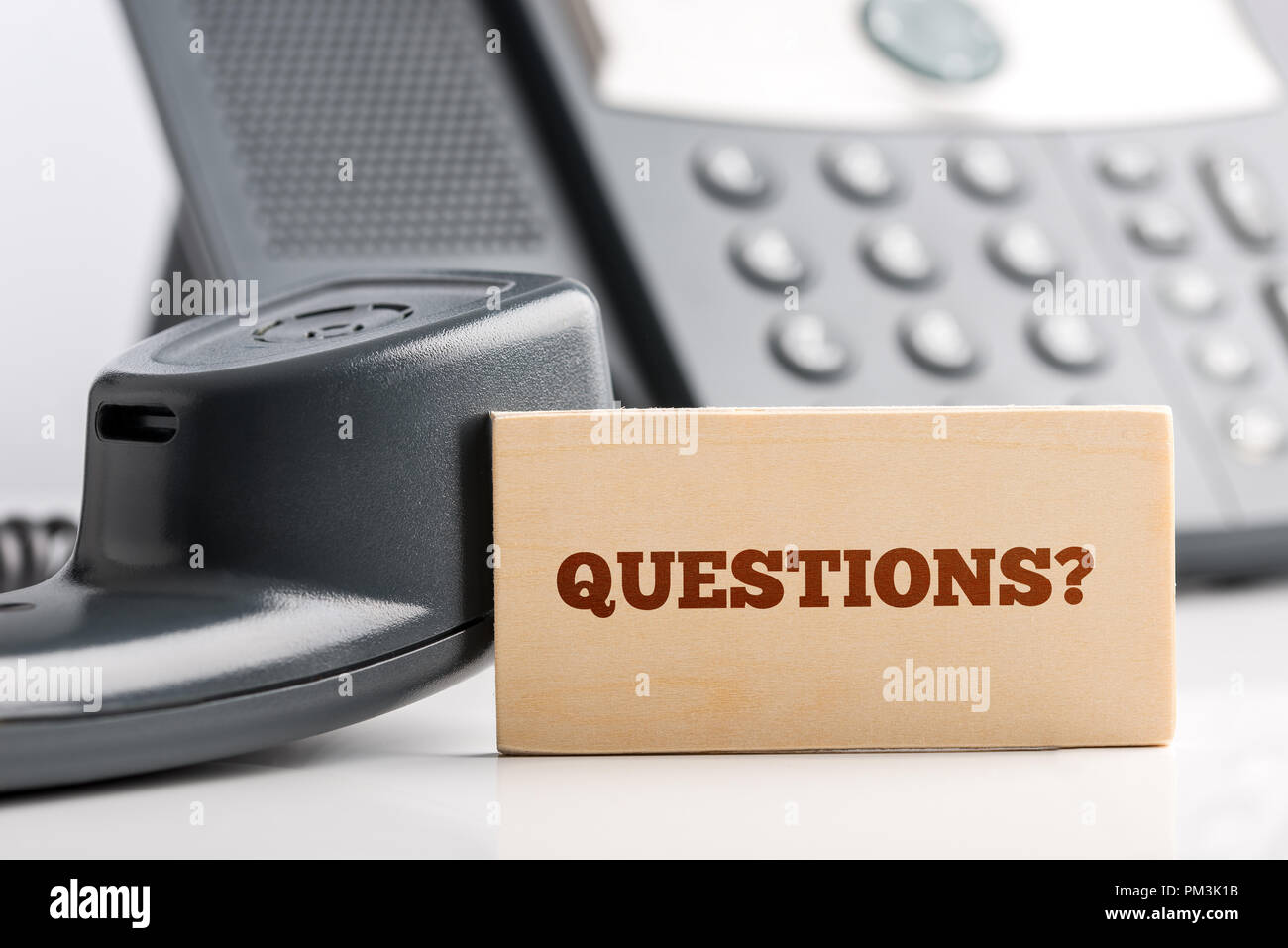 Close up Small Signage for Questions on White Telephone Desk Stock ...