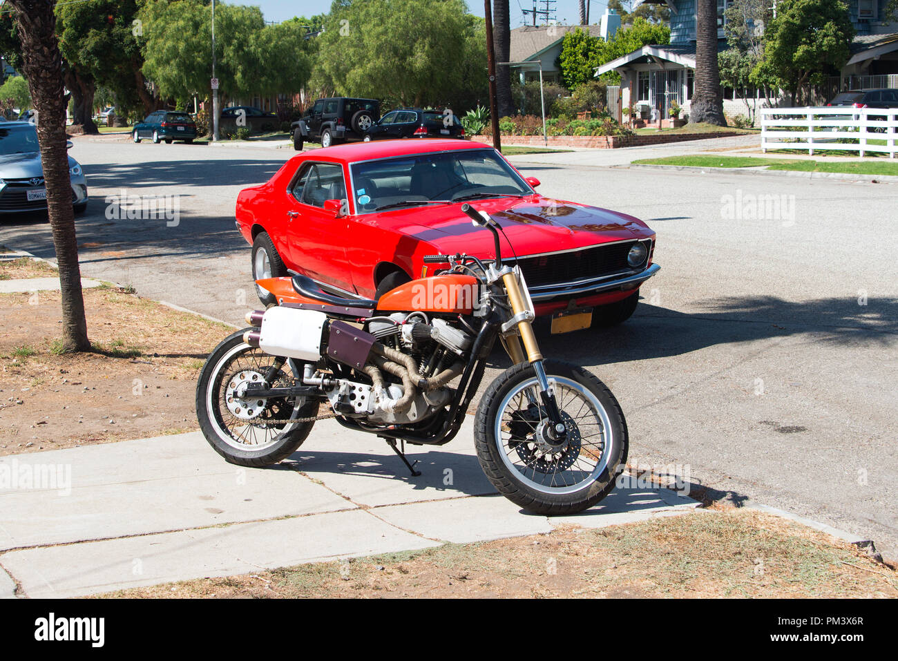 A view of a classic vintage motorcycle and a car in the street in LA ...