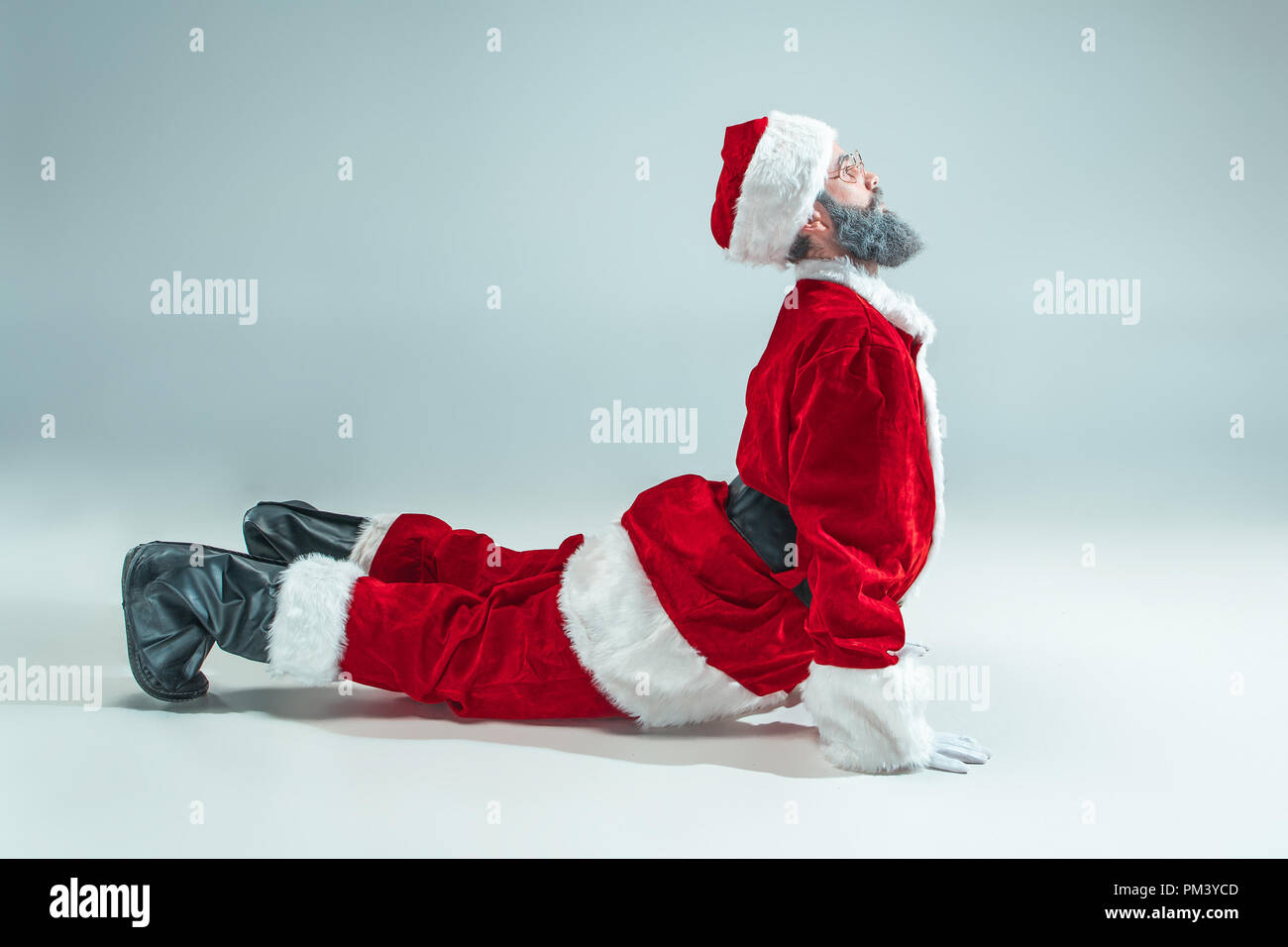 Funny serious guy with christmas hat dancing at studio. New Year ...