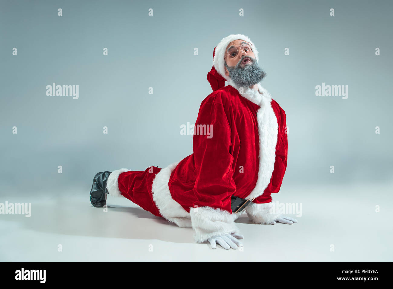 Funny serious guy with christmas hat dancing at studio. New Year ...